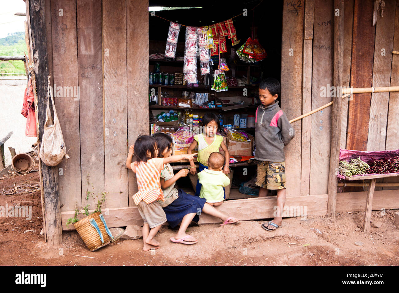 Local children visit the local store at a village in the Oudomxai ...