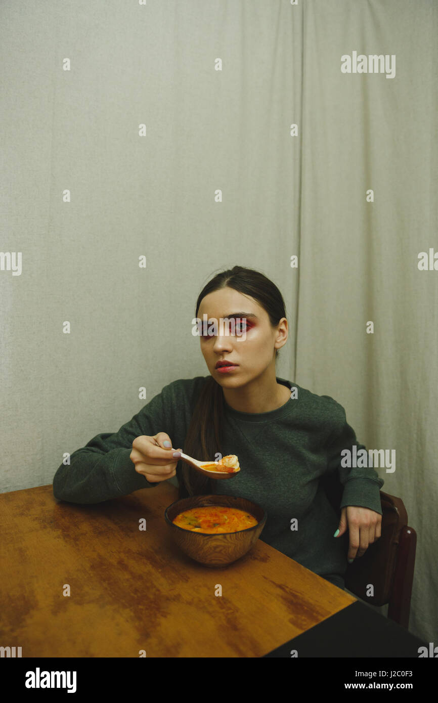 Vertical picture of a calm woman in sweater eating in eatery while ...