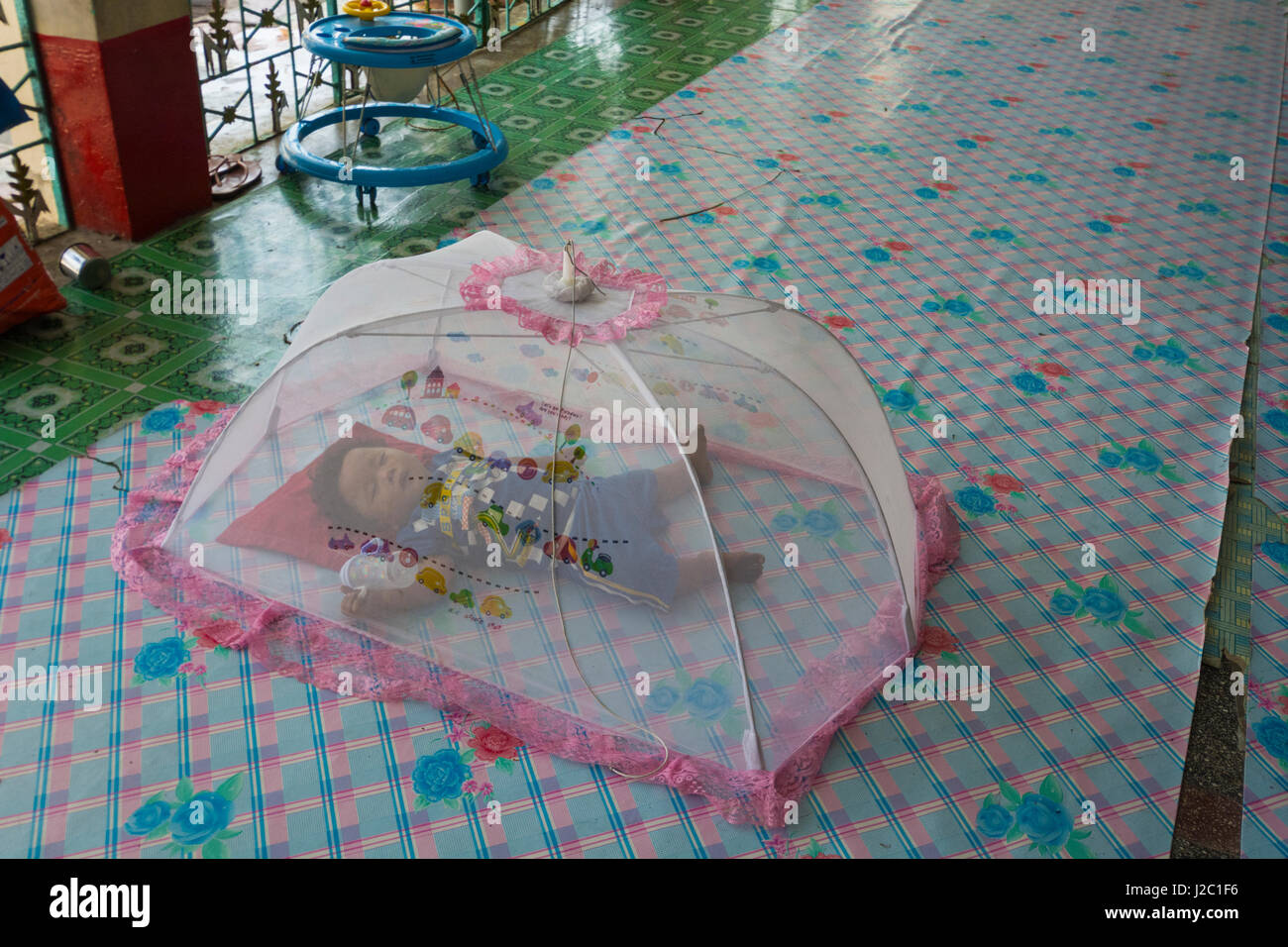 Myanmar. Yangon. Botataung Pagoda. Baby napping under a screen Stock ...