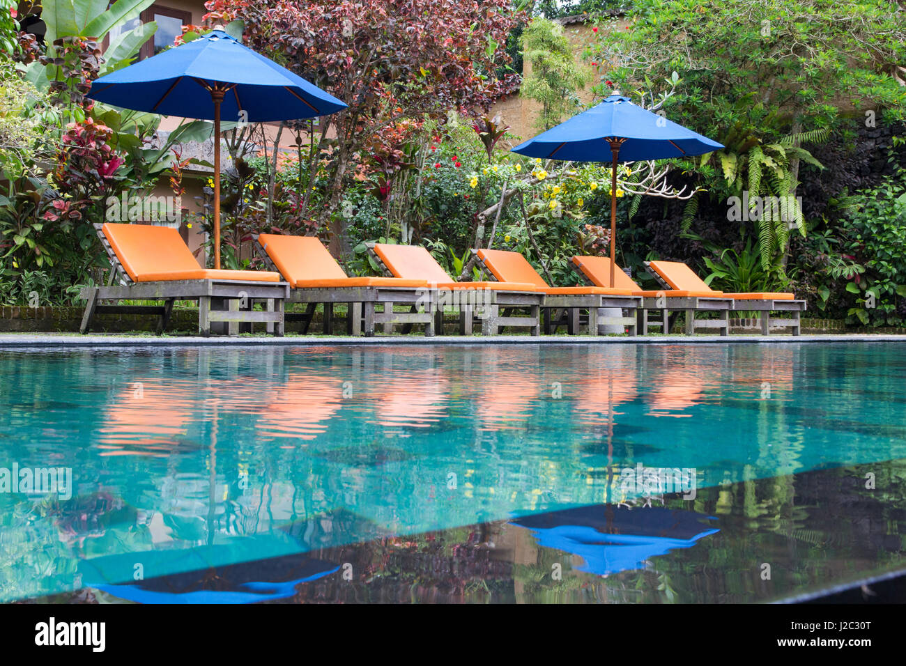 Indonesia, Bali. Reflections of lounges in hotel swimming pool in Bali ...