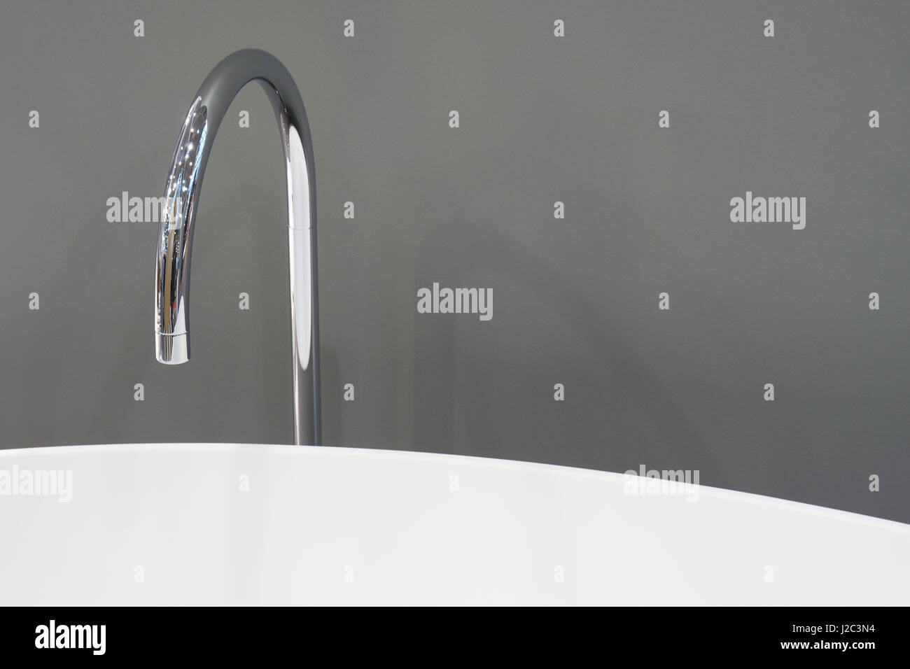 White bath and water tap on gray background Stock Photo - Alamy