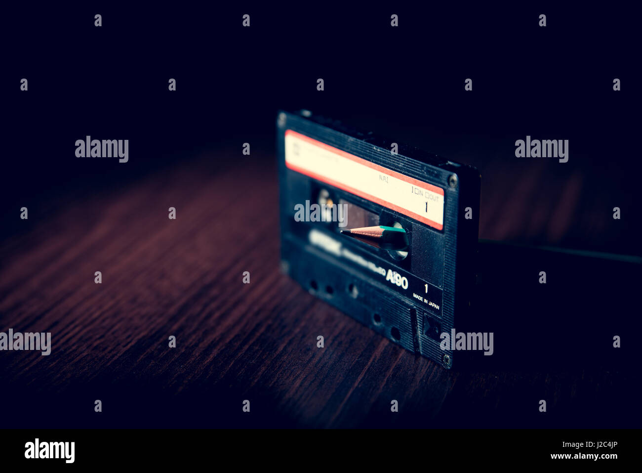 Old-fashioned cassette tape on the dark surface and green pencil Stock ...