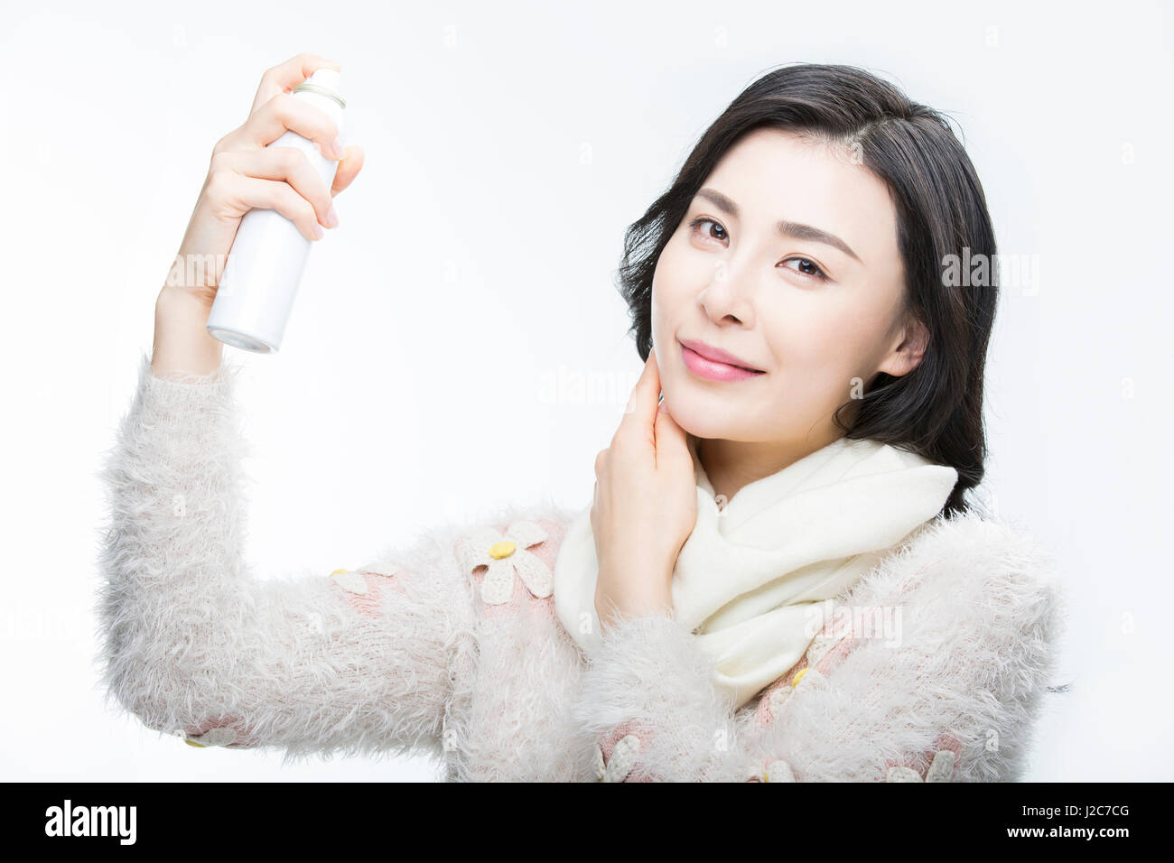 Portrait of young smiling woman spraying mist Stock Photo - Alamy