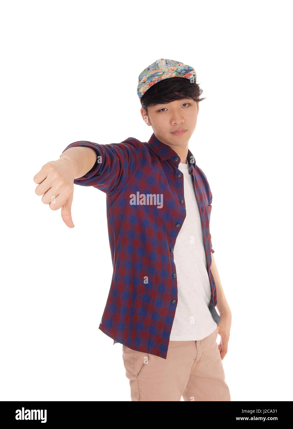 A handsome Asian man standing gesturing with his thump down in a ...