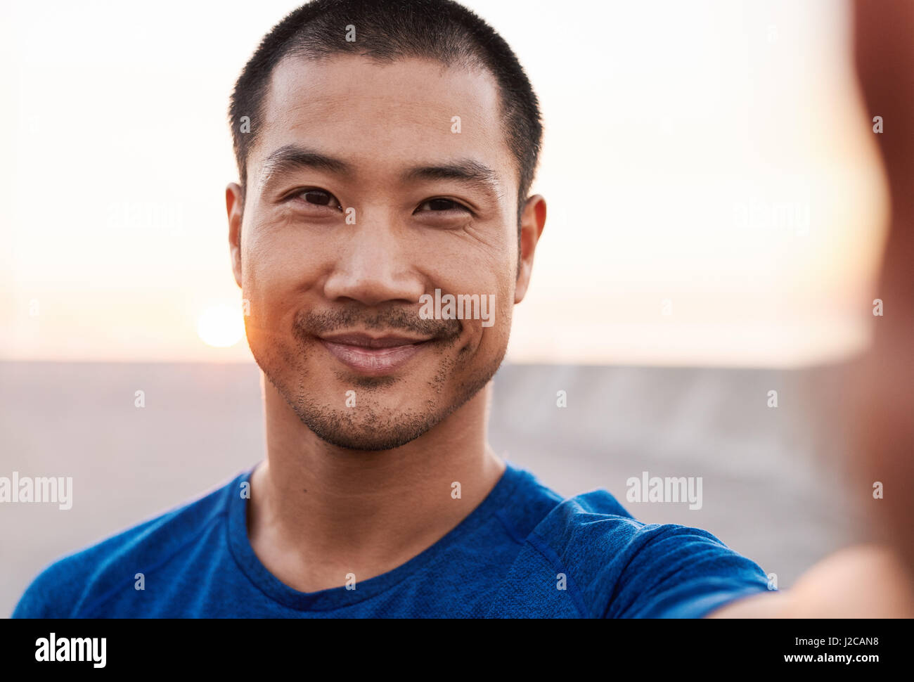 Athletic Asian man smiling while out for a morning run Stock Photo - Alamy