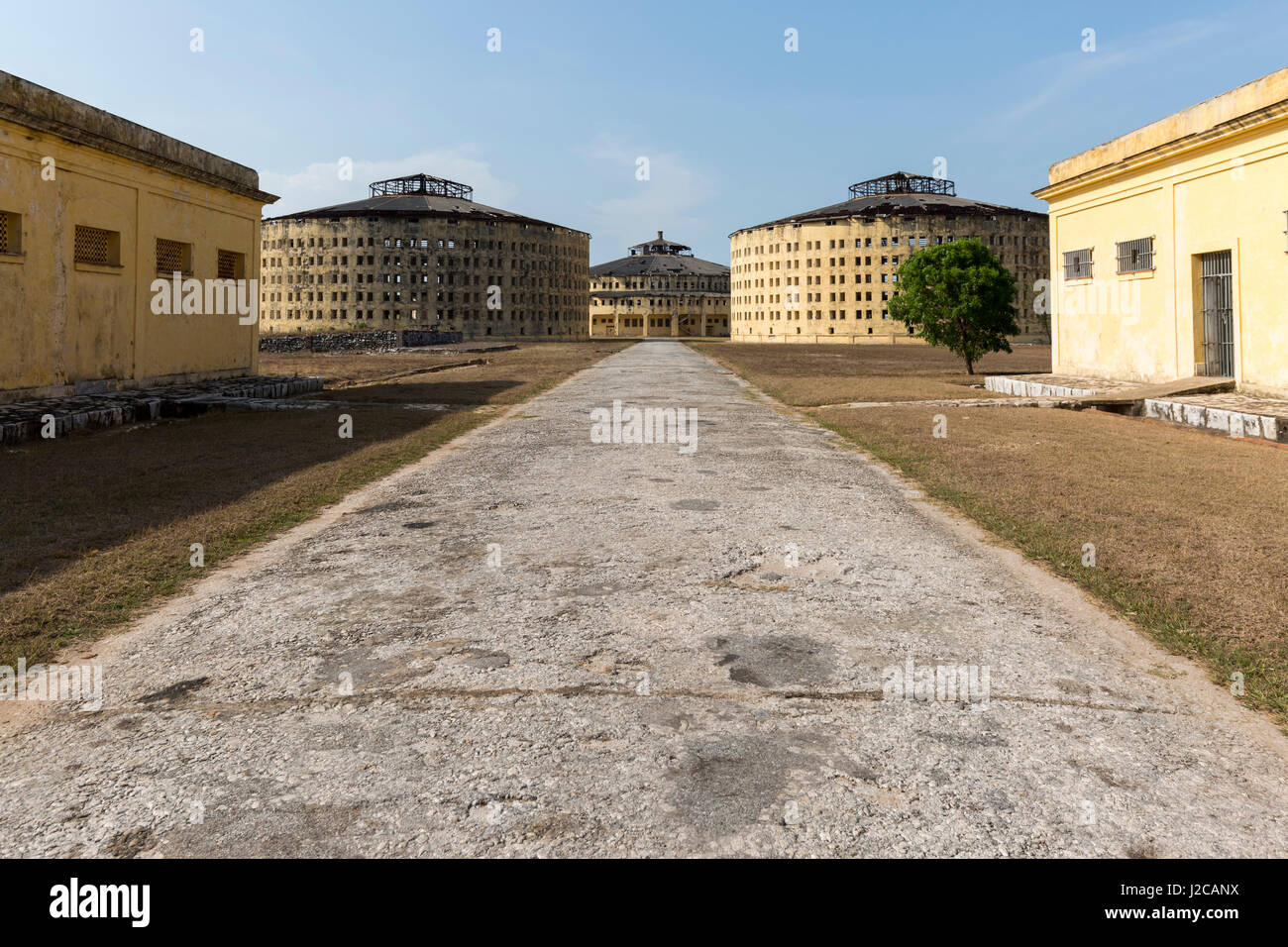 A road leading into the middle of three old building structures making ...