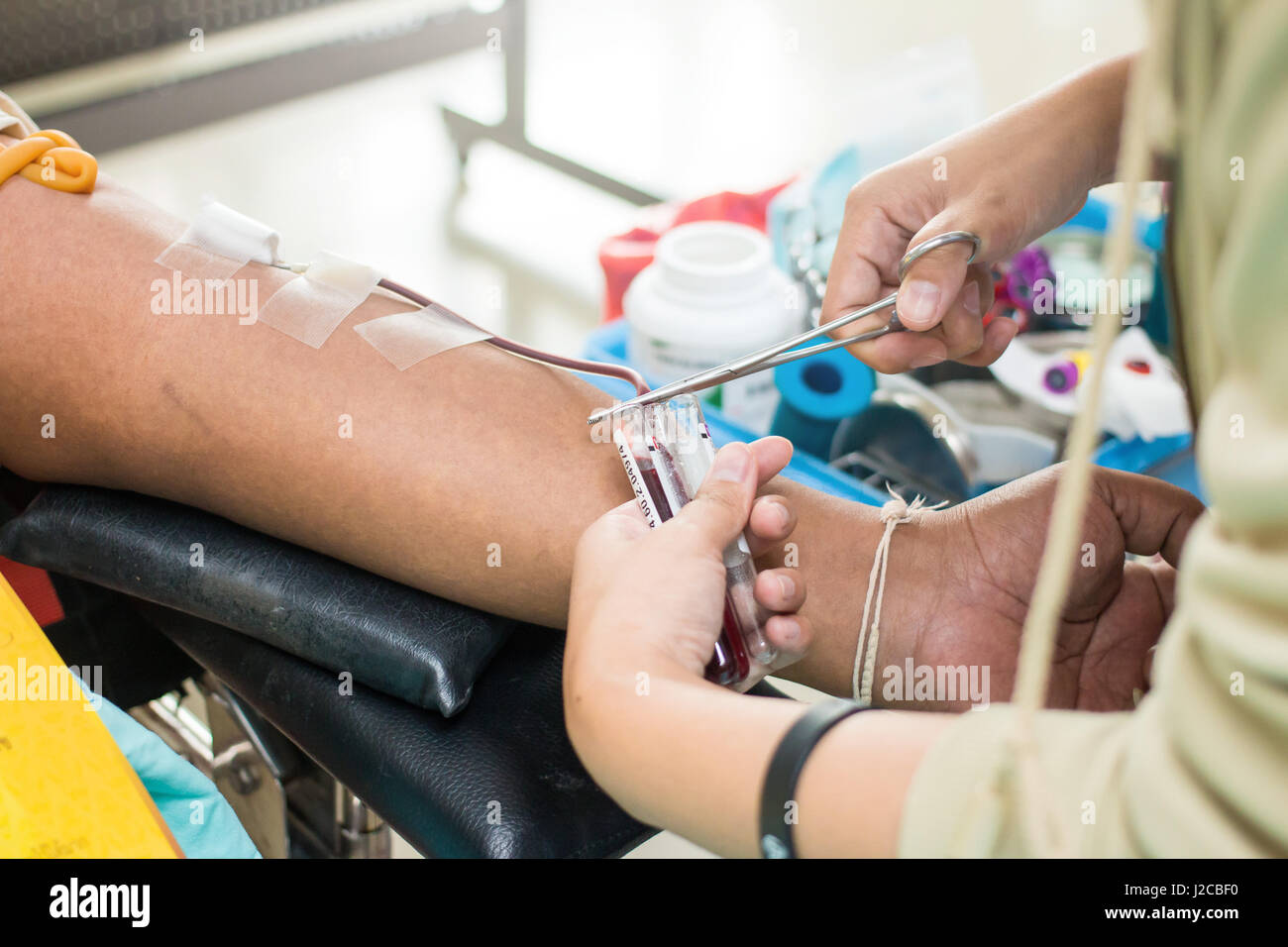 Donate blood using a needle in the arm Stock Photo - Alamy