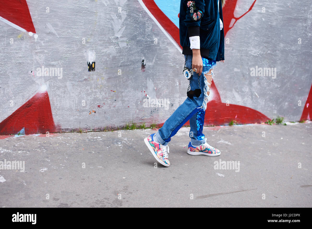 Woman in ripped jeans with metallic blue front panels, crop Stock Photo ...