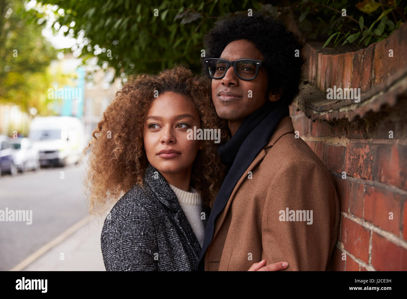 Couple Standing By Wall On City Street And Hugging Stock Photo - Alamy