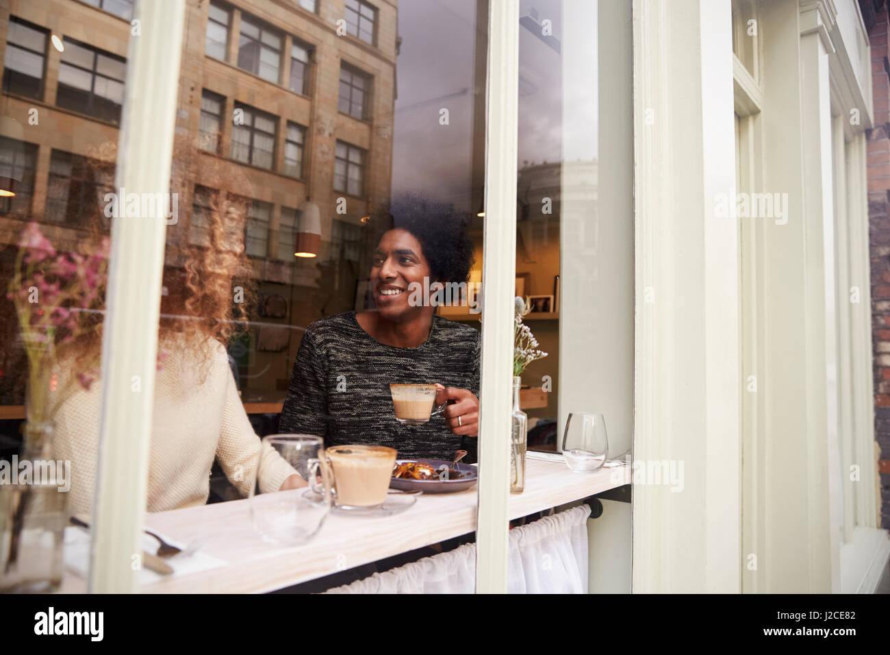 View Through Window Of Couple Enjoying Drink In Coffee Shop Stock Photo ...