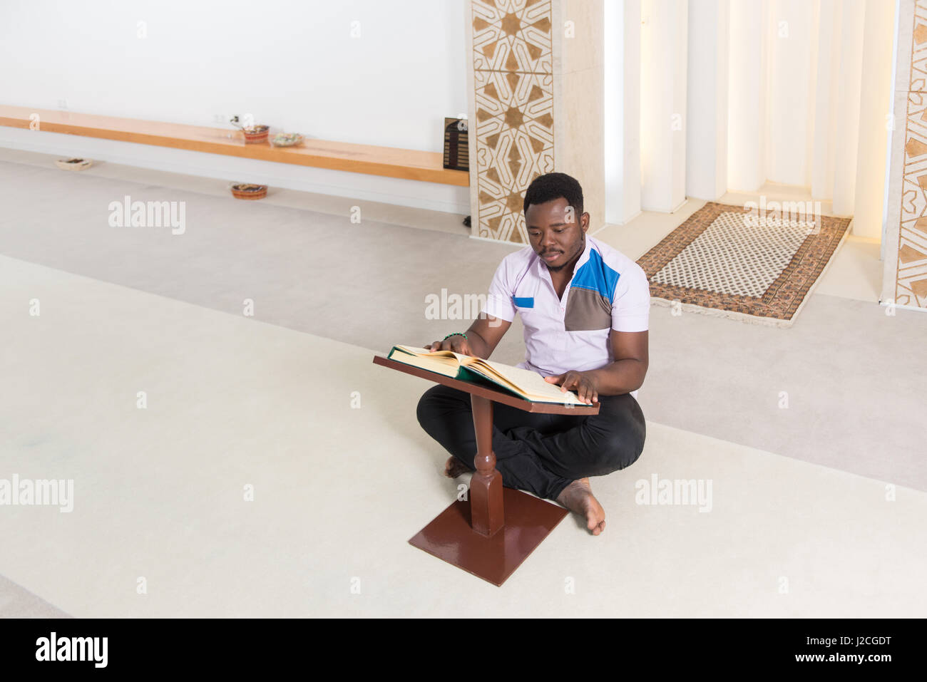 Black African Muslim Man Is Reading The Koran Stock Photo - Alamy