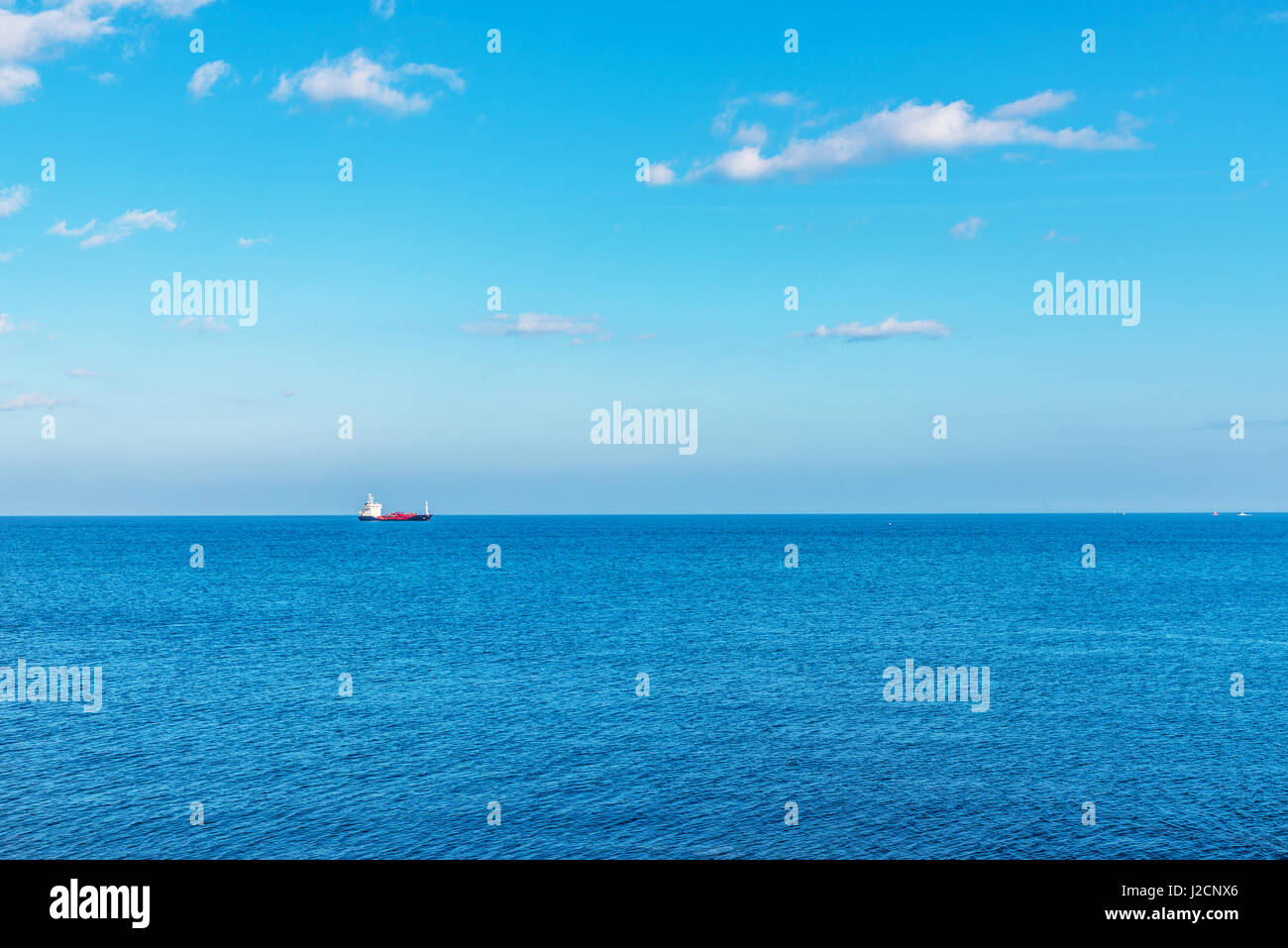A view of the enormous ocean, in the distance a flowing ship, beautiful ...