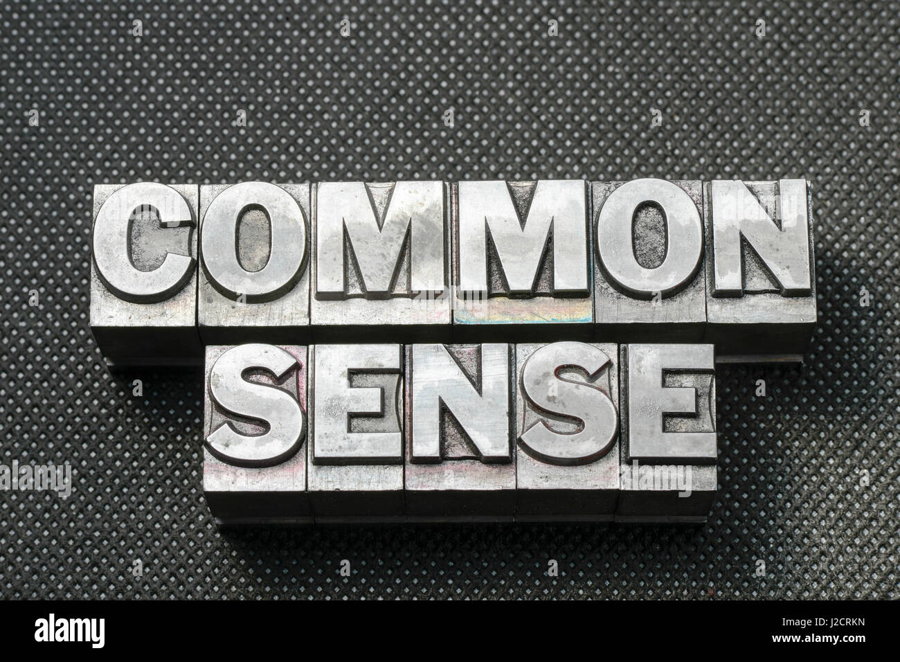 common sense phrase made from metallic letterpress blocks on black ...