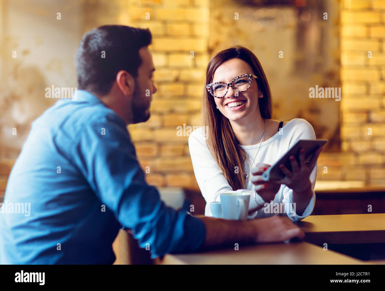 Happy young couple browsing the internet at the tablet Stock Photo - Alamy
