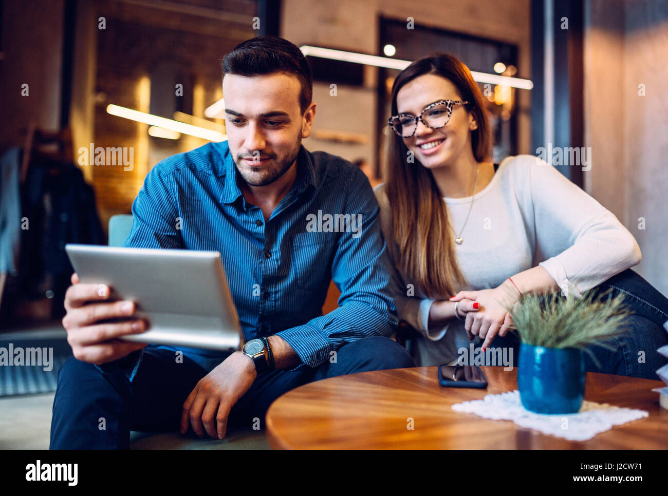 Happy young couple browsing the internet at the tablet Stock Photo - Alamy