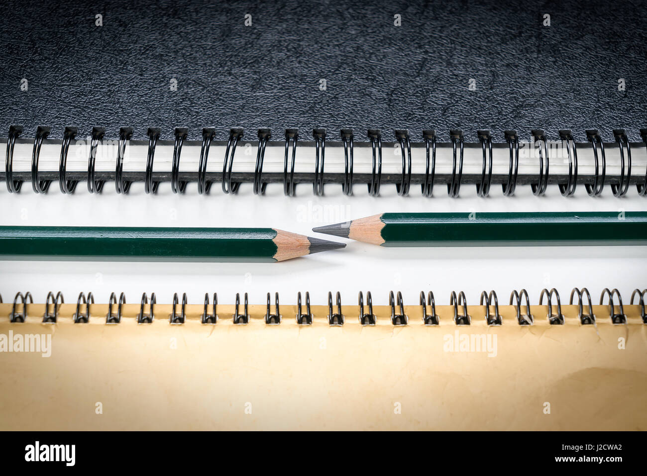 two green pencils between note books Stock Photo - Alamy