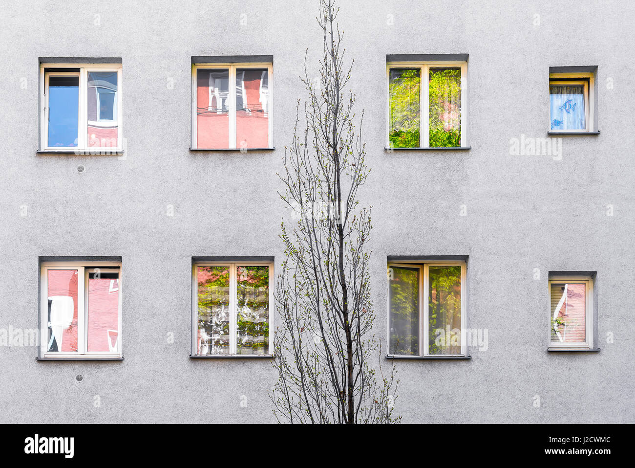 simple gray facade of a house with colored reflections in the windows ...