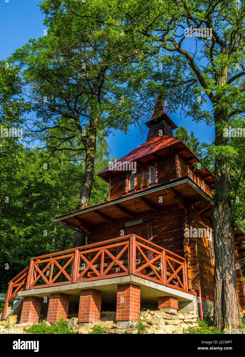 Old wooden chapel between big trees with blue sky in background Stock ...
