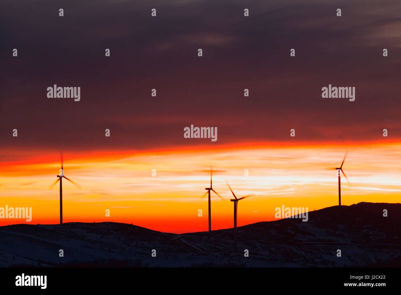 Four wind turbines on mountain ridge Stock Photo - Alamy