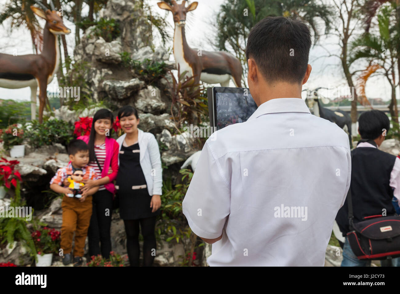Vietnam, Hue. Man photographing family with tablet device Stock Photo ...
