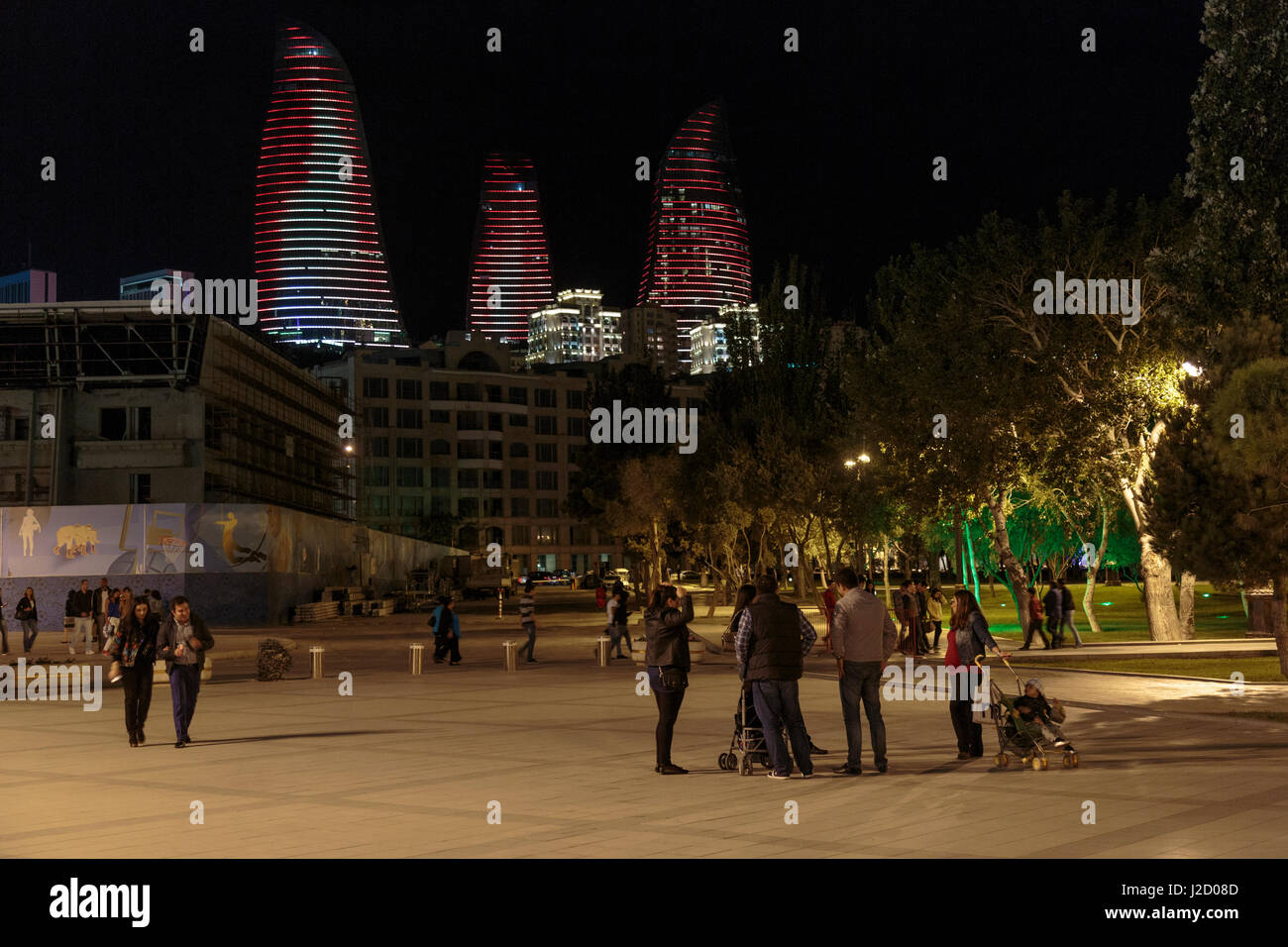 Azerbaijan, Baku. People gather around a park at night, with the Flame ...