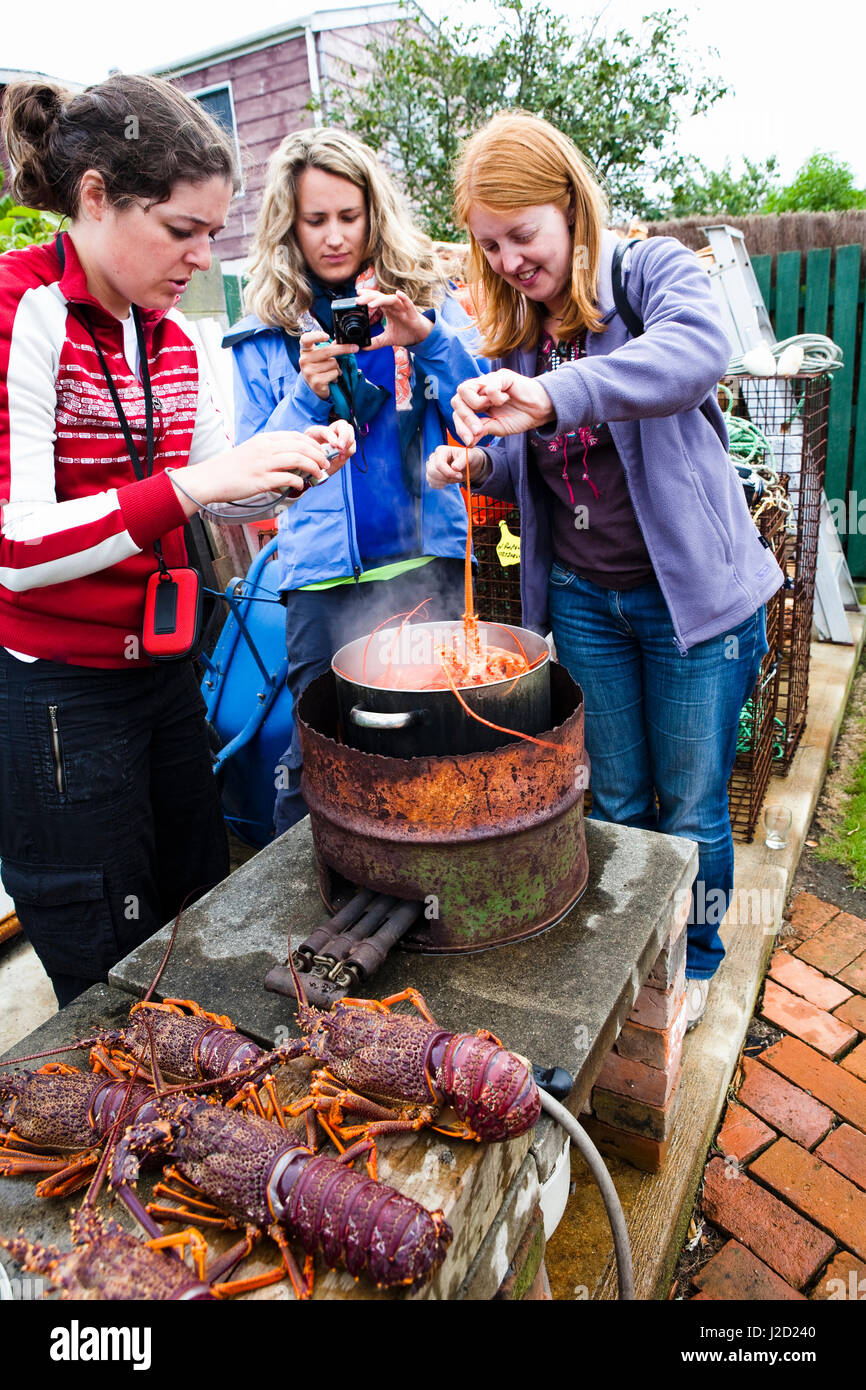 Girls prepare freshly caught crayfish for dinner in Kaikoura, New ...