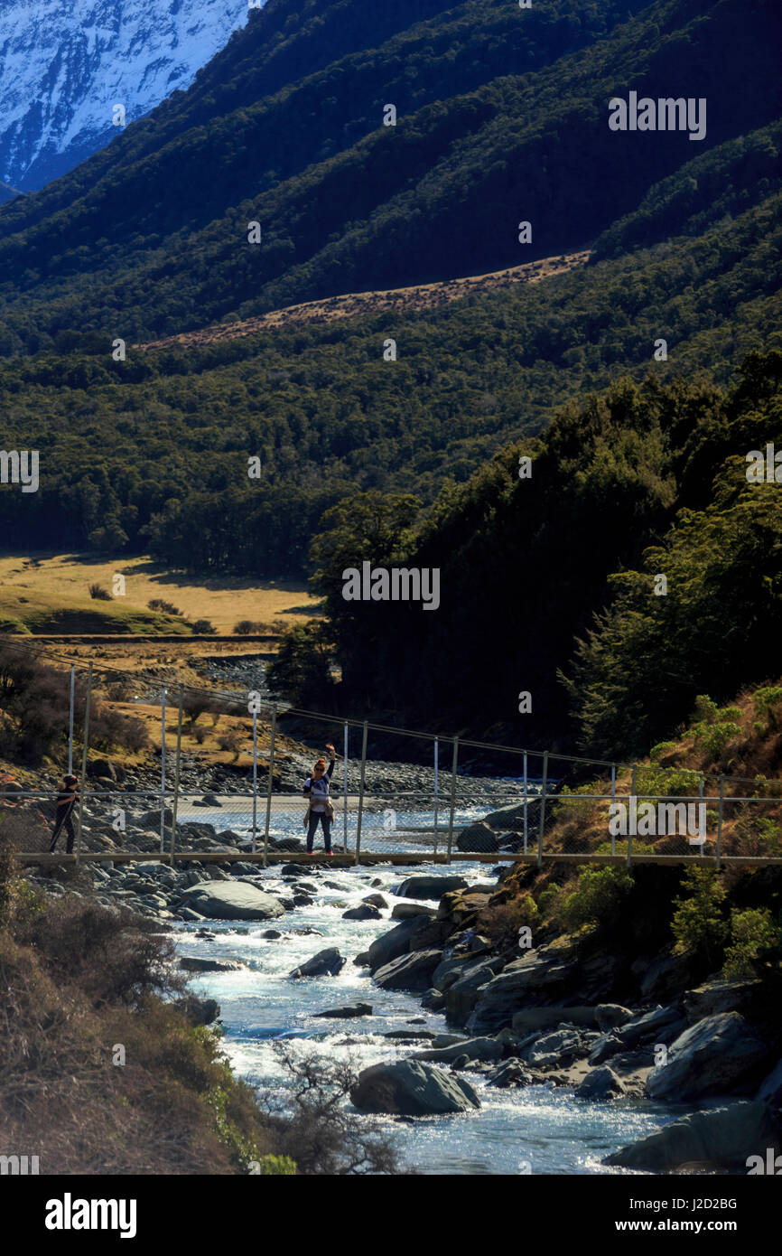 A long suspension bridge over a river on the Fox Glacier track, Wanaka ...