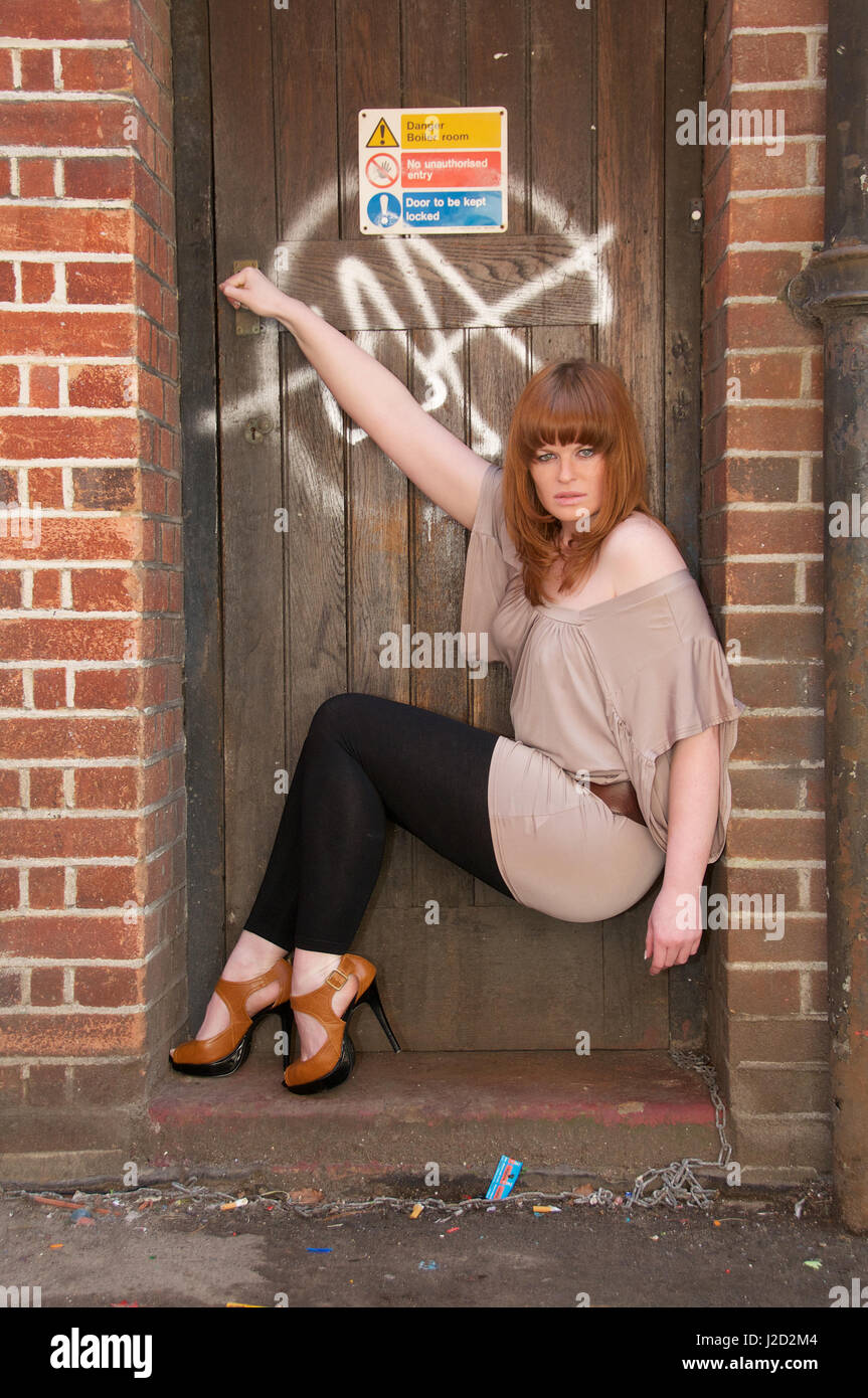 Beautiful ginger haired girl wearing black and tan in an urban location ...