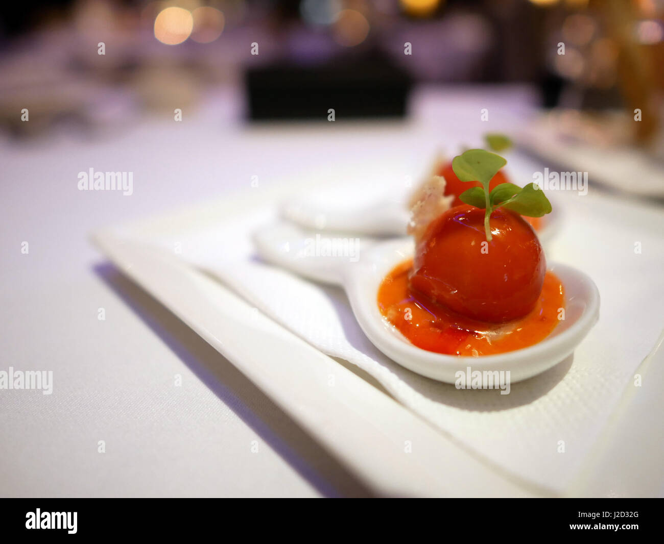 Red tomatoes with chili sauce are served in fine dining restaurant ...
