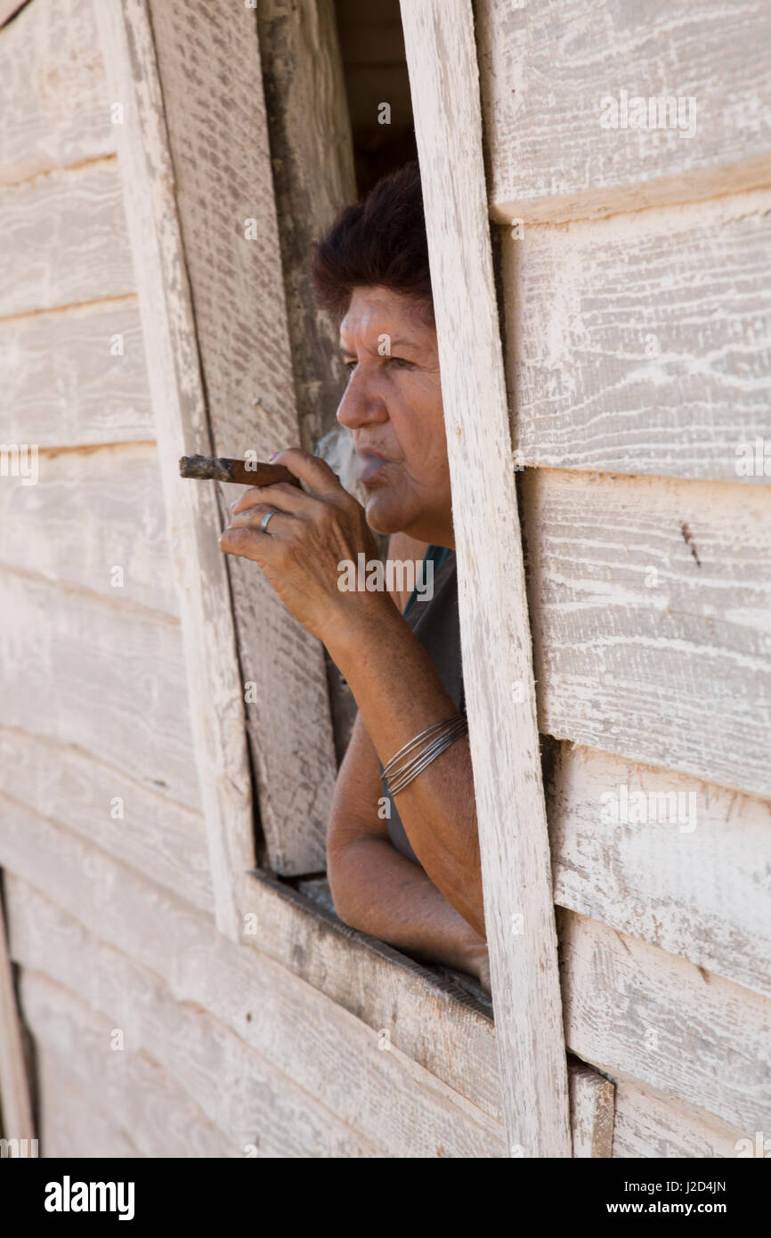 Cuba, Vinales, woman smoking cigar in window. (Editorial Use Only Stock ...