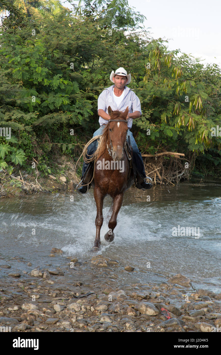 Cuba, Trinidad, man riding horse through river. (Editorial Use Only ...