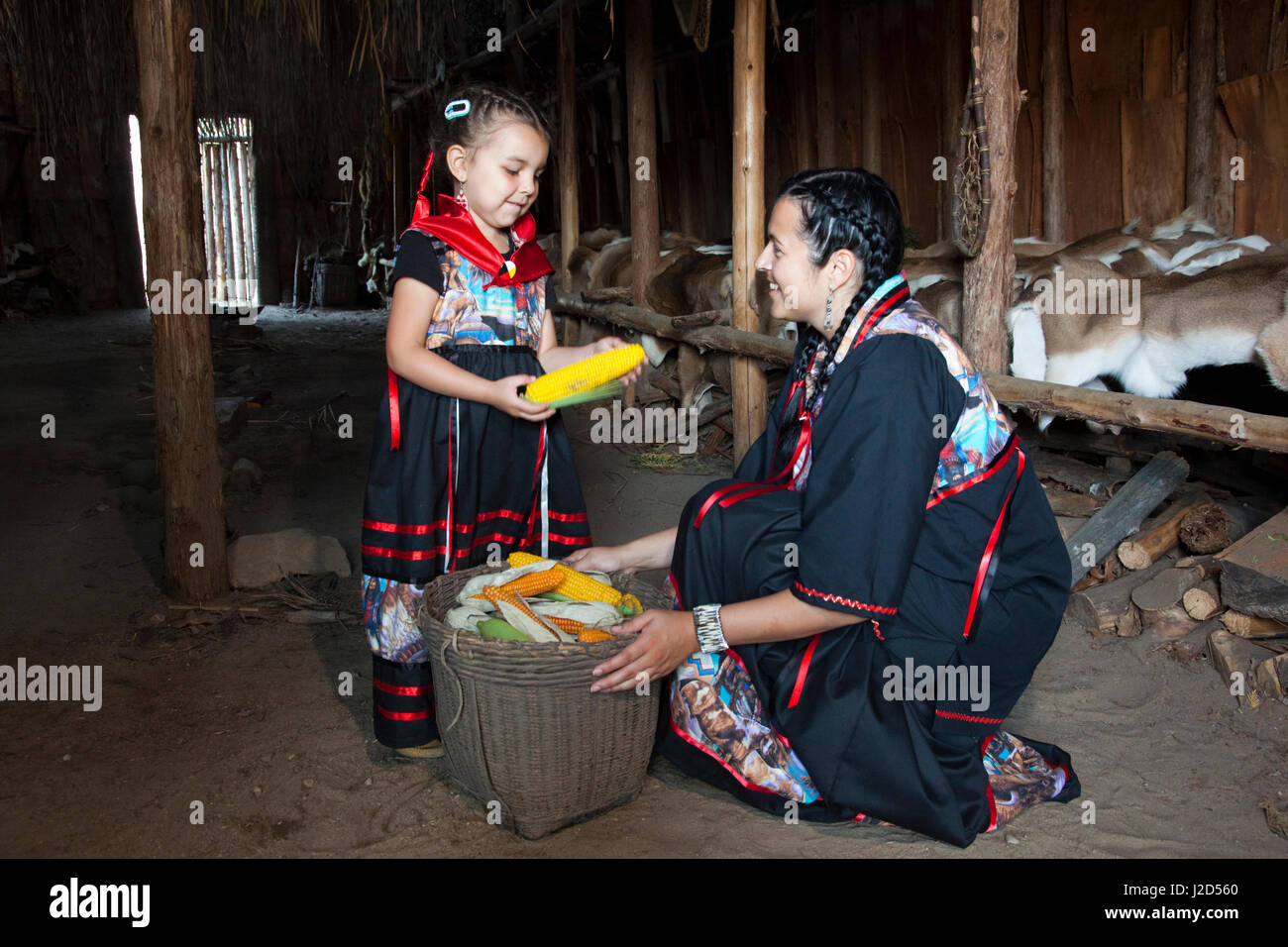 Ojibwe mother and daughter dressed in traditional ribbon dresses with a ...