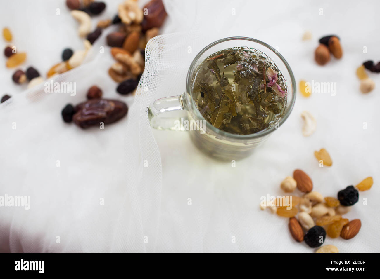 a mug of green tea rests on a white table Stock Photo - Alamy