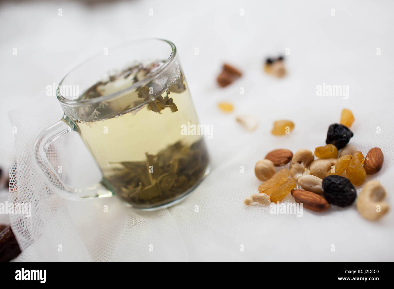 a mug of green tea rests on a white table Stock Photo - Alamy