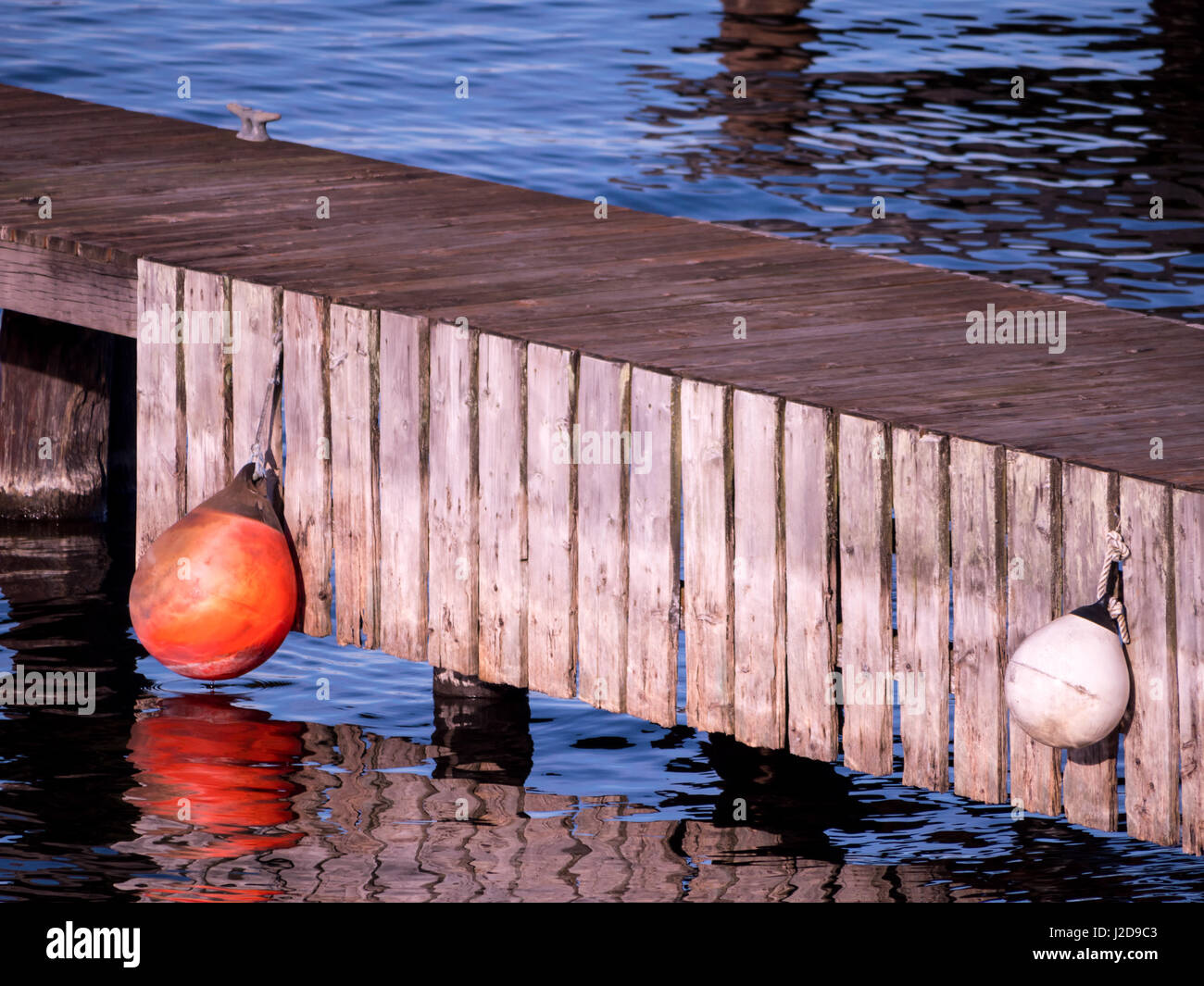 Wood dock with round floats, reflections and copy space Stock Photo - Alamy
