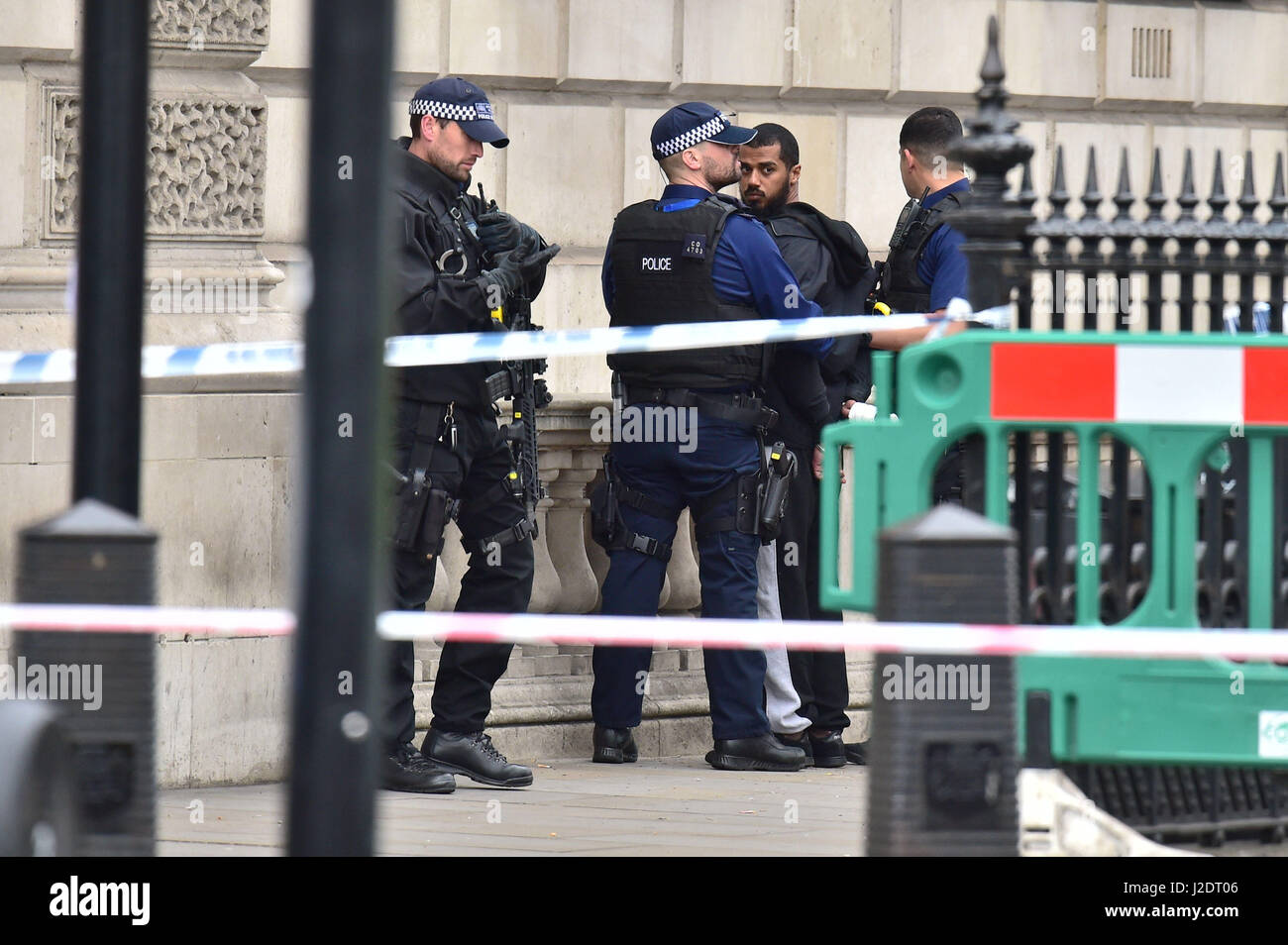 Armed police talk to man at the scene after a person was arrested ...