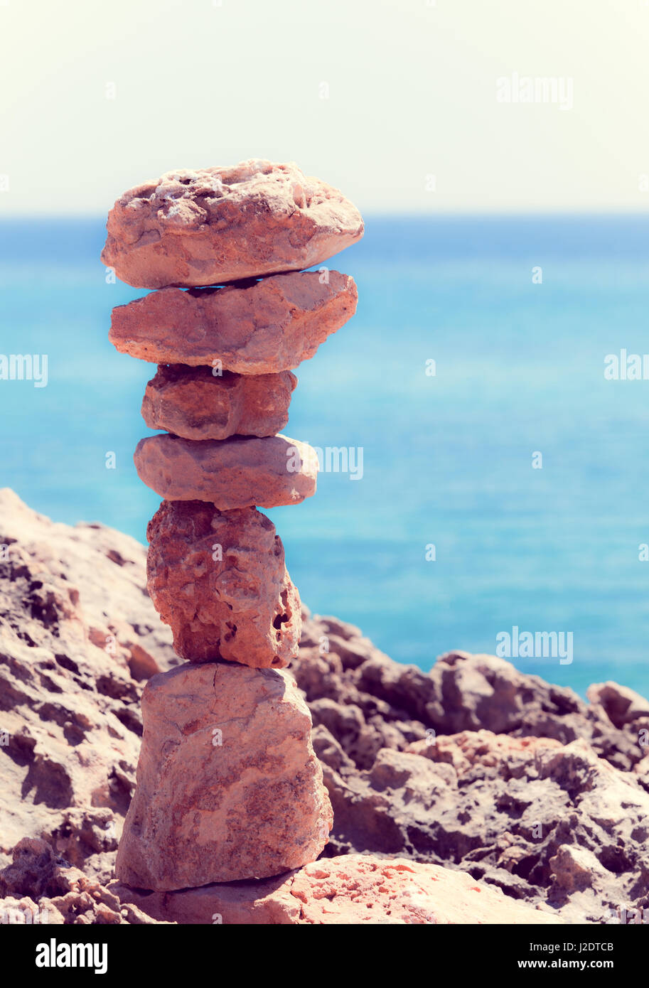 Balanced stones, pebbles stacks against blue sea with a instagram ...