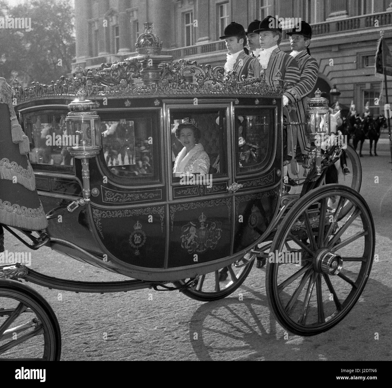 Queen Elizabeth II, wearing an evening gown of gold tissue and a coat ...