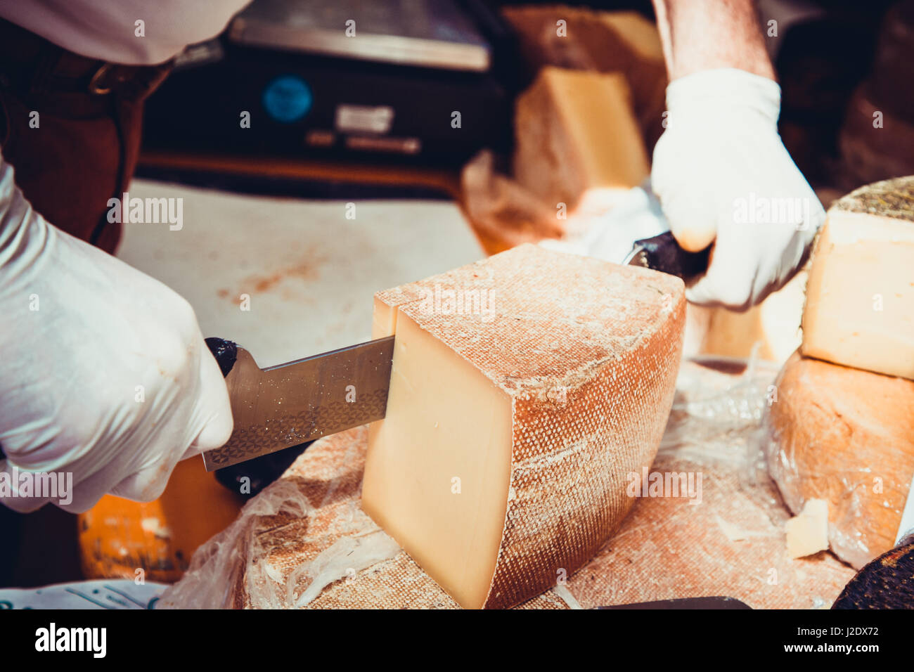 Worker slicing the cheese. Close up of Cutting cheese Stock Photo - Alamy