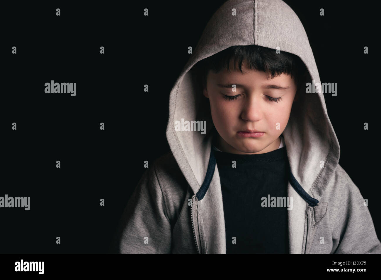 Sad boy on black background Stock Photo - Alamy