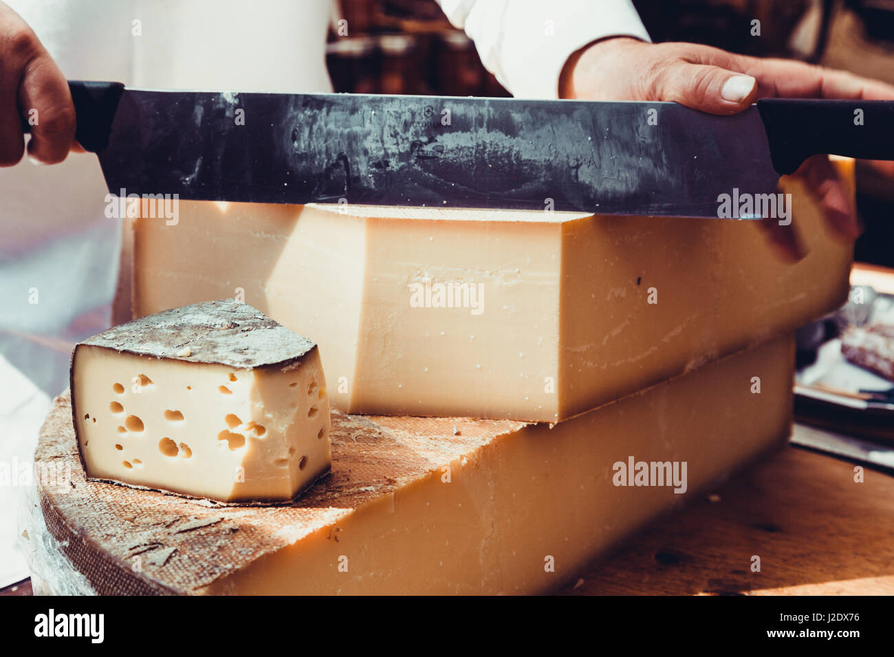 Worker slicing the cheese. Close up of Cutting cheese Stock Photo - Alamy