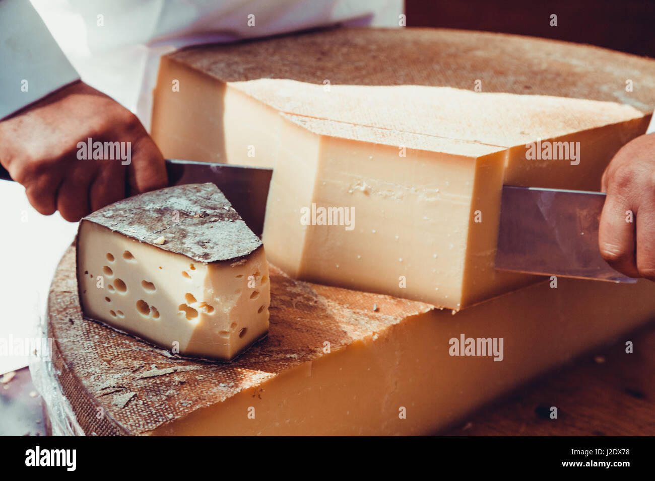 Worker slicing the cheese. Close up of Cutting cheese Stock Photo - Alamy