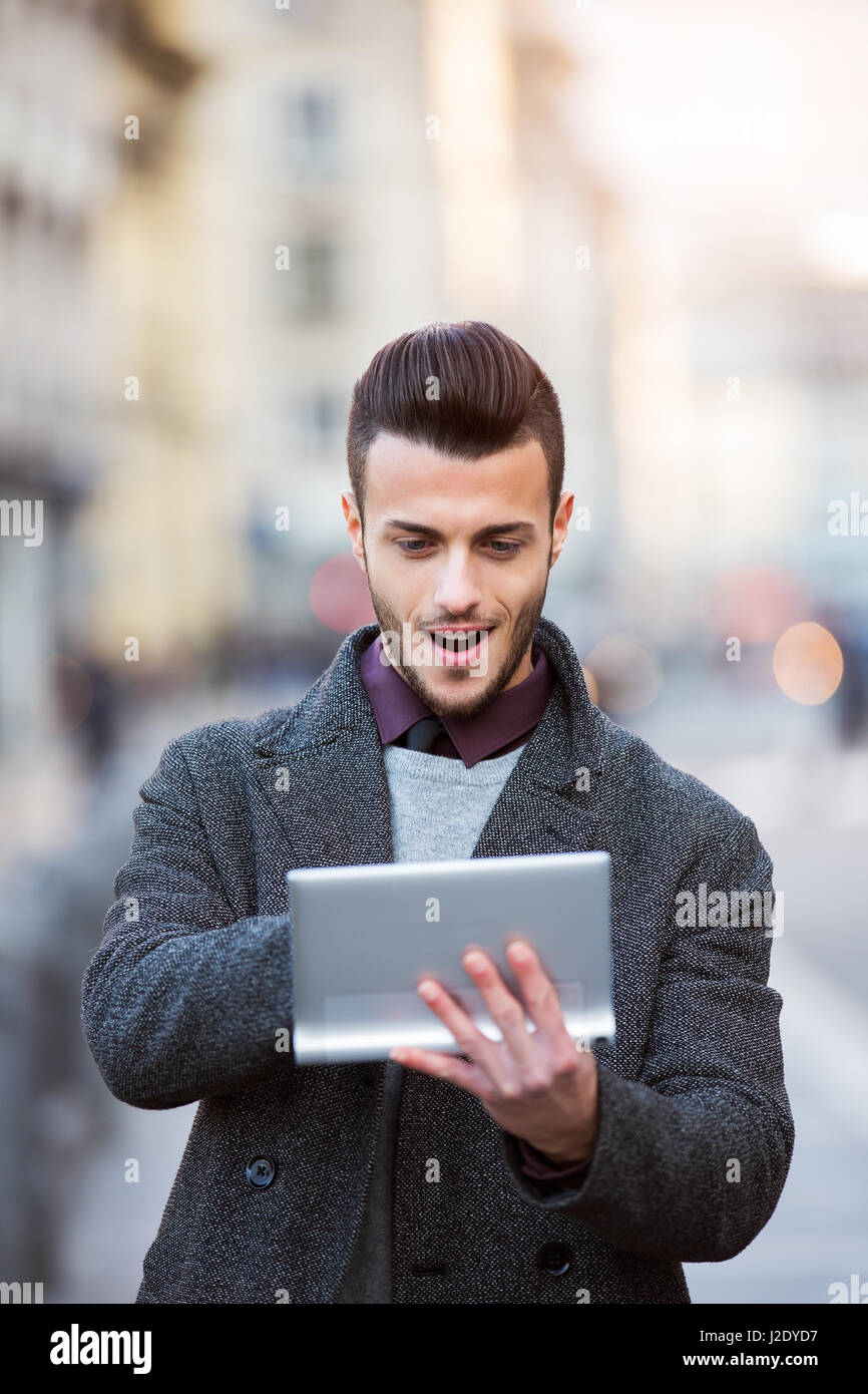 Handsome young man using modern digital tablet. Toned photo Stock Photo ...