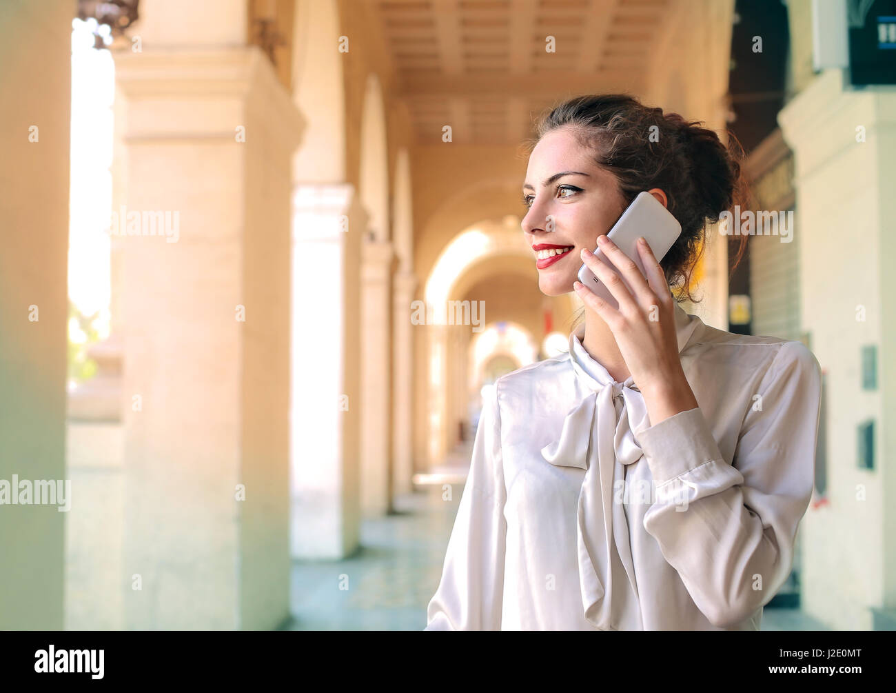 Brunette woman making a call outside Stock Photo - Alamy