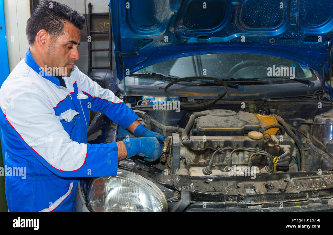 Car mechanic fixing an engine in his garage. copy space Stock Photo - Alamy