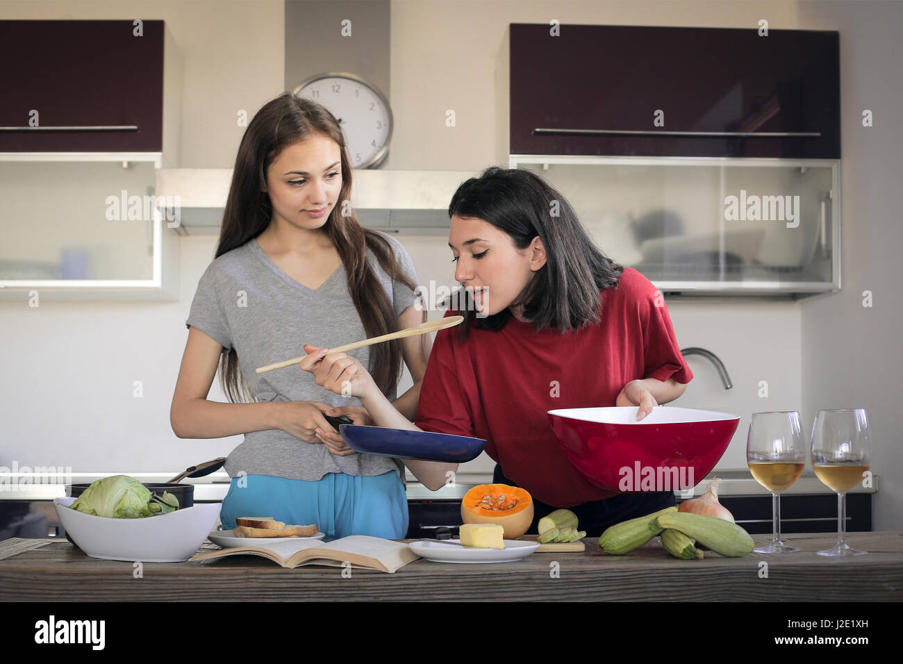 2 women cooking together in kitchen Stock Photo - Alamy