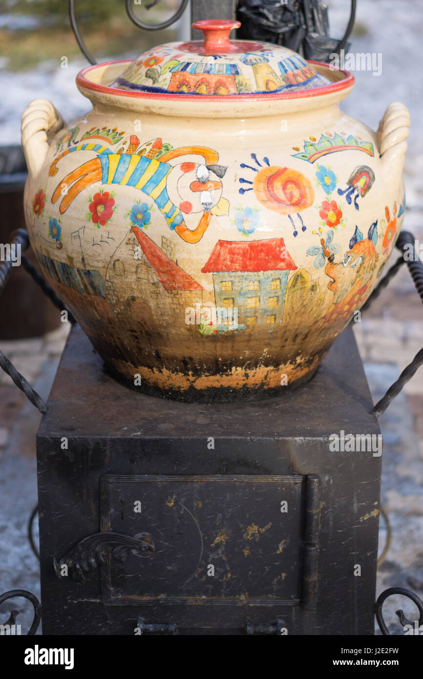 big ceramic cauldron on a small iron stove with colorful painting ...