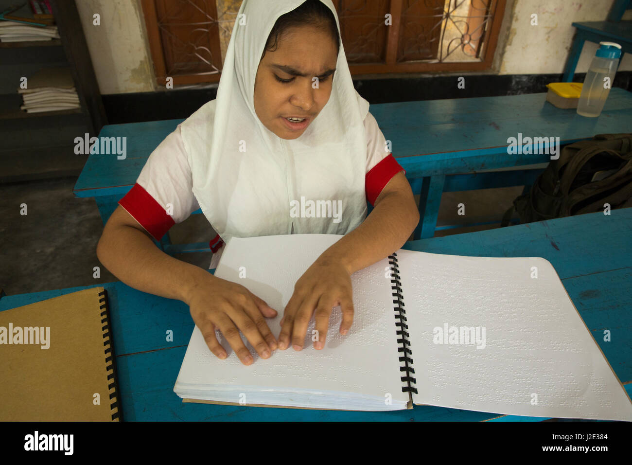 Visually impaired girl student learns in classroom with the help of ...