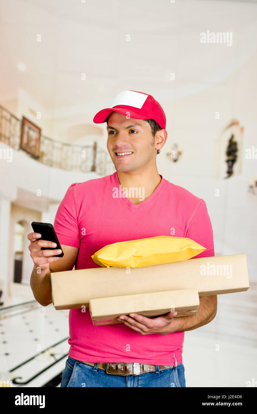 Delivery man in pink uniform holding boxes and documents Stock Photo ...