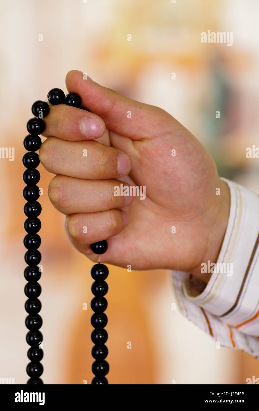 Arabian guy praying to god and holding a masbaha Stock Photo - Alamy